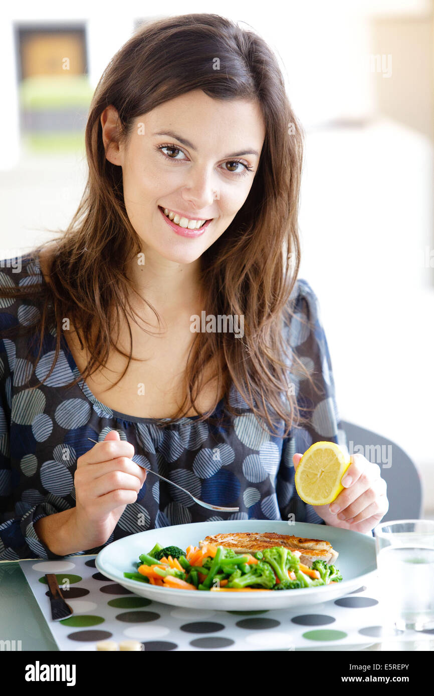 Woman eating fish Stock Photo - Alamy