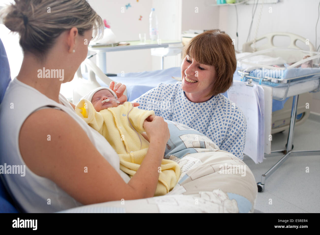 Pediatric auxiliary nurse talking to the mother of a premature newborn ...