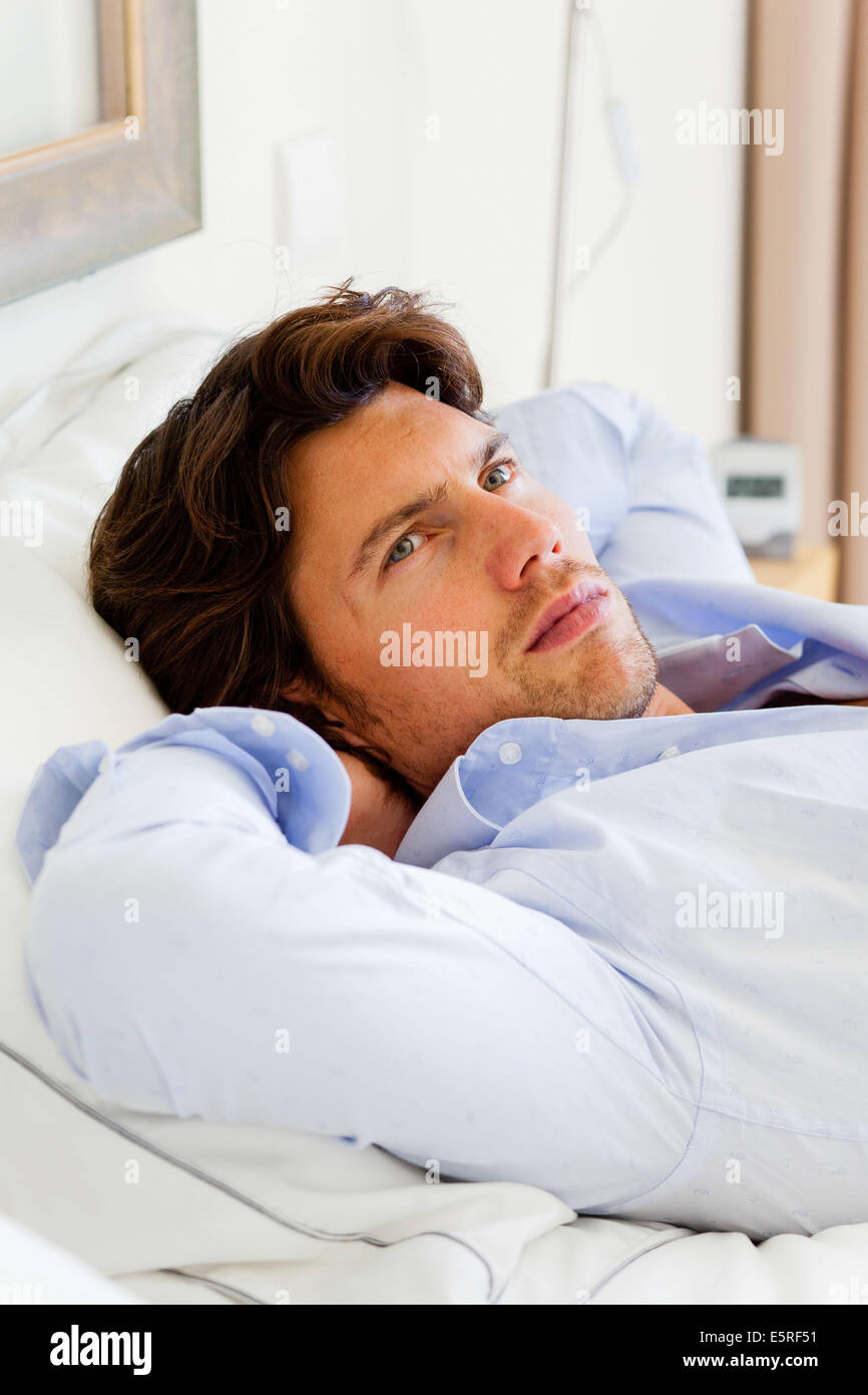 Man relaxing on bed Stock Photo - Alamy