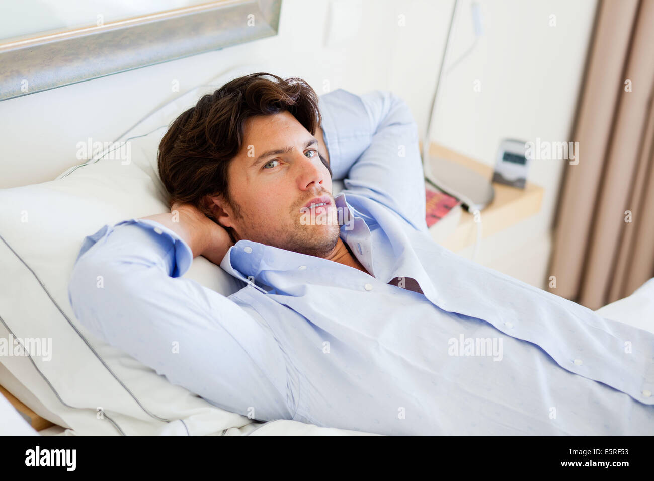 Man relaxing on bed Stock Photo - Alamy