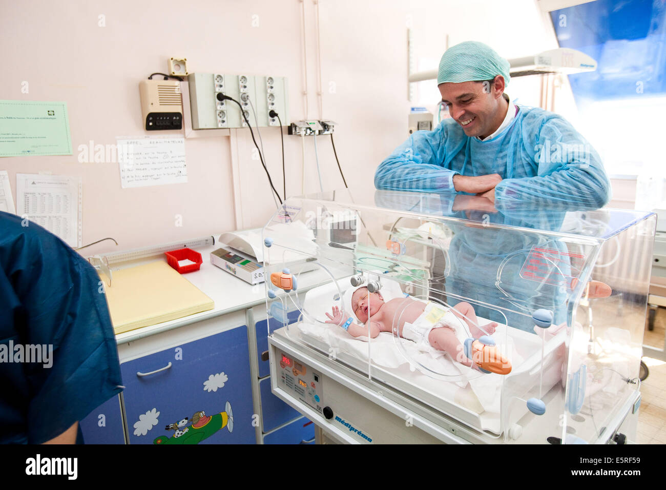 Father looking at his newborn baby on an incubator, Maternity ...