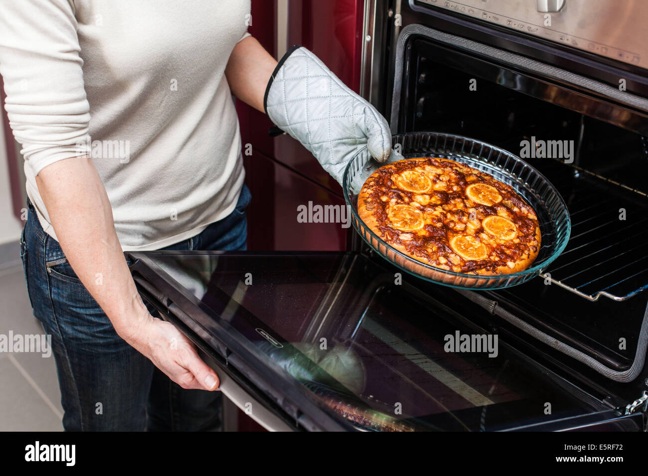 Woman using oven Stock Photo - Alamy
