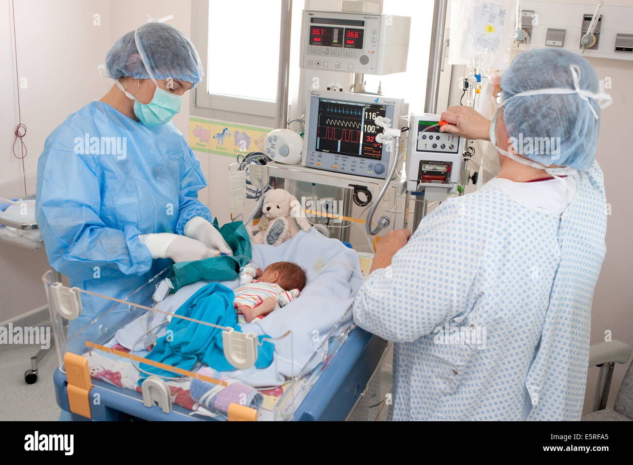 Pediatric nurse placing drip to a premature newborn baby, Obstetrics ...