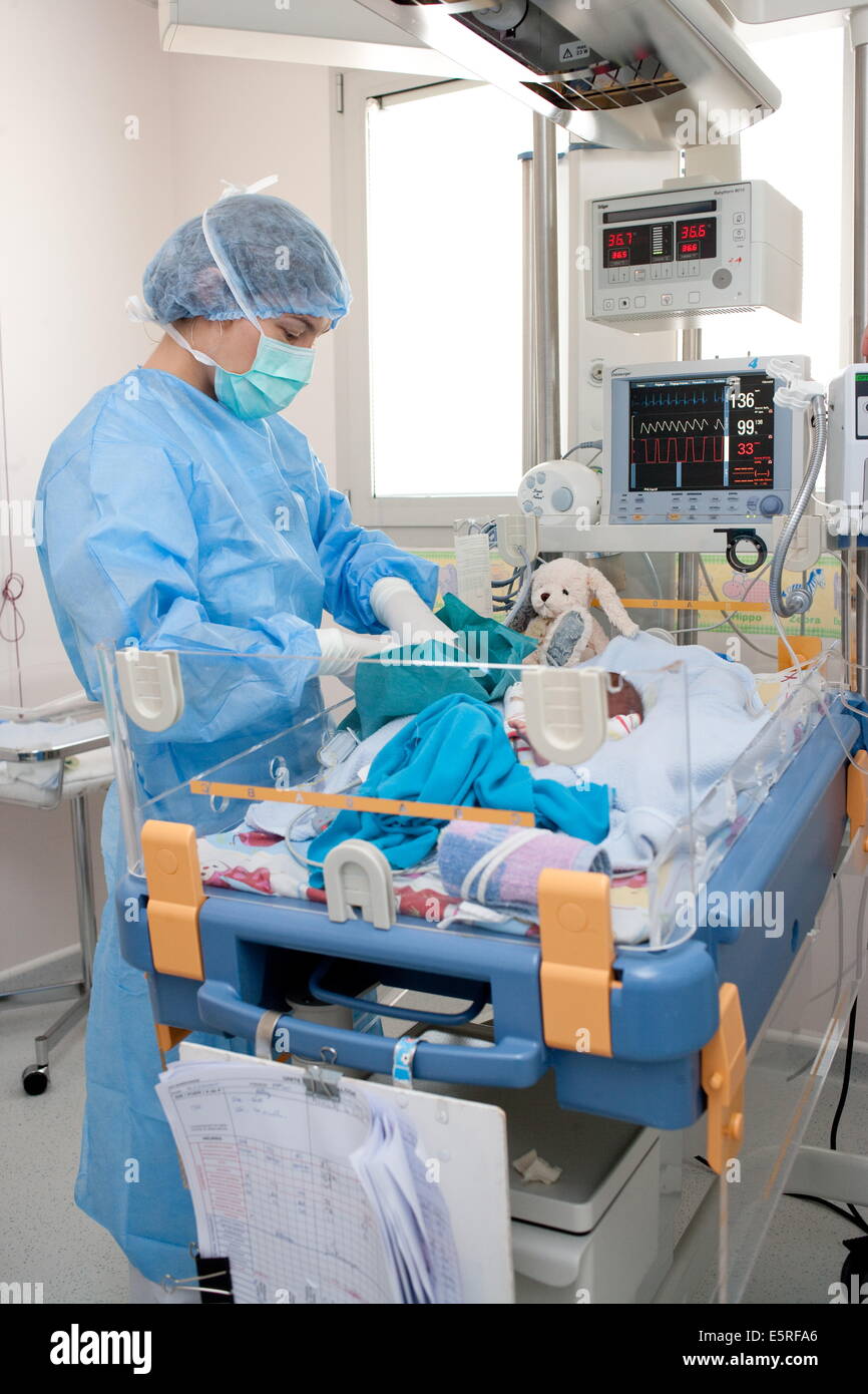 Pediatric nurse placing drip to a premature newborn baby, Obstetrics ...