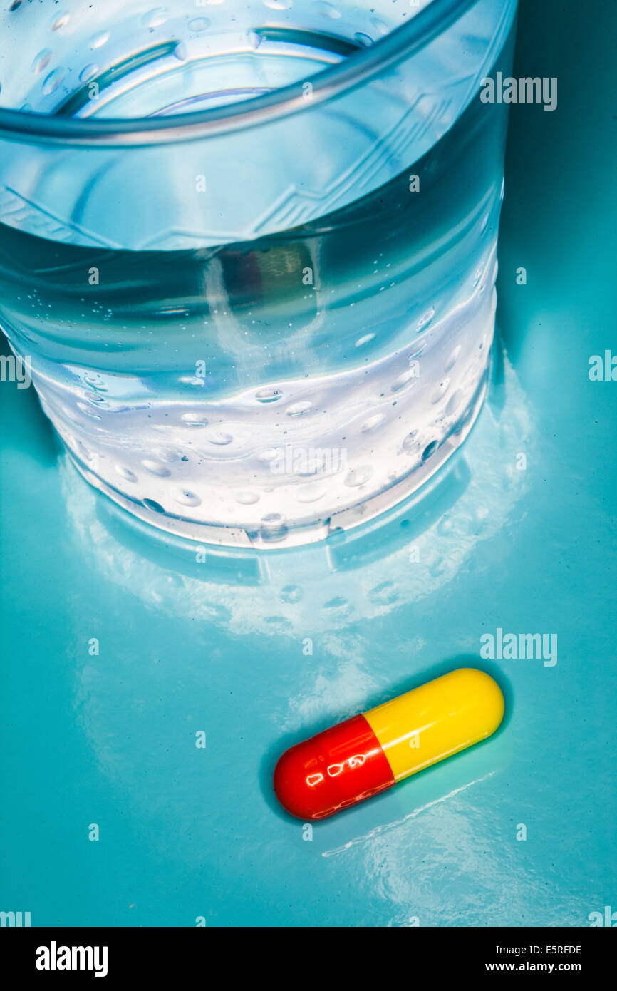 Capsule and glass of water Stock Photo - Alamy