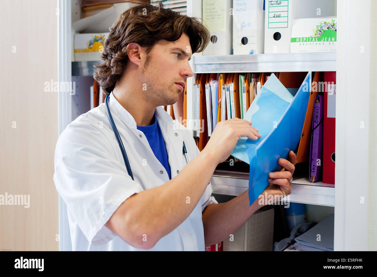 Doctor reading medical records in a hospital Stock Photo - Alamy