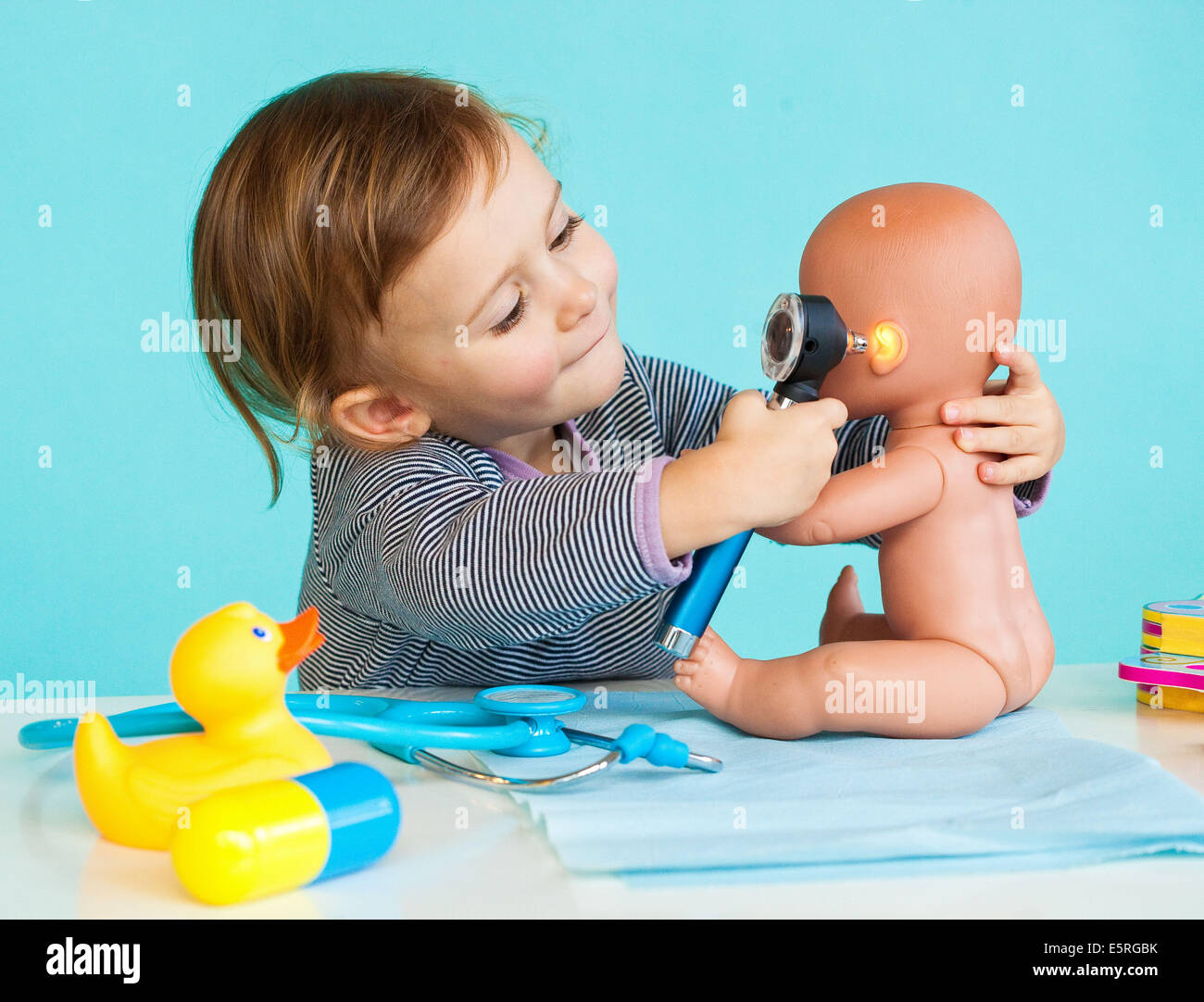 2 year old girl giving care to her dolly with her doctor outfit Stock ...