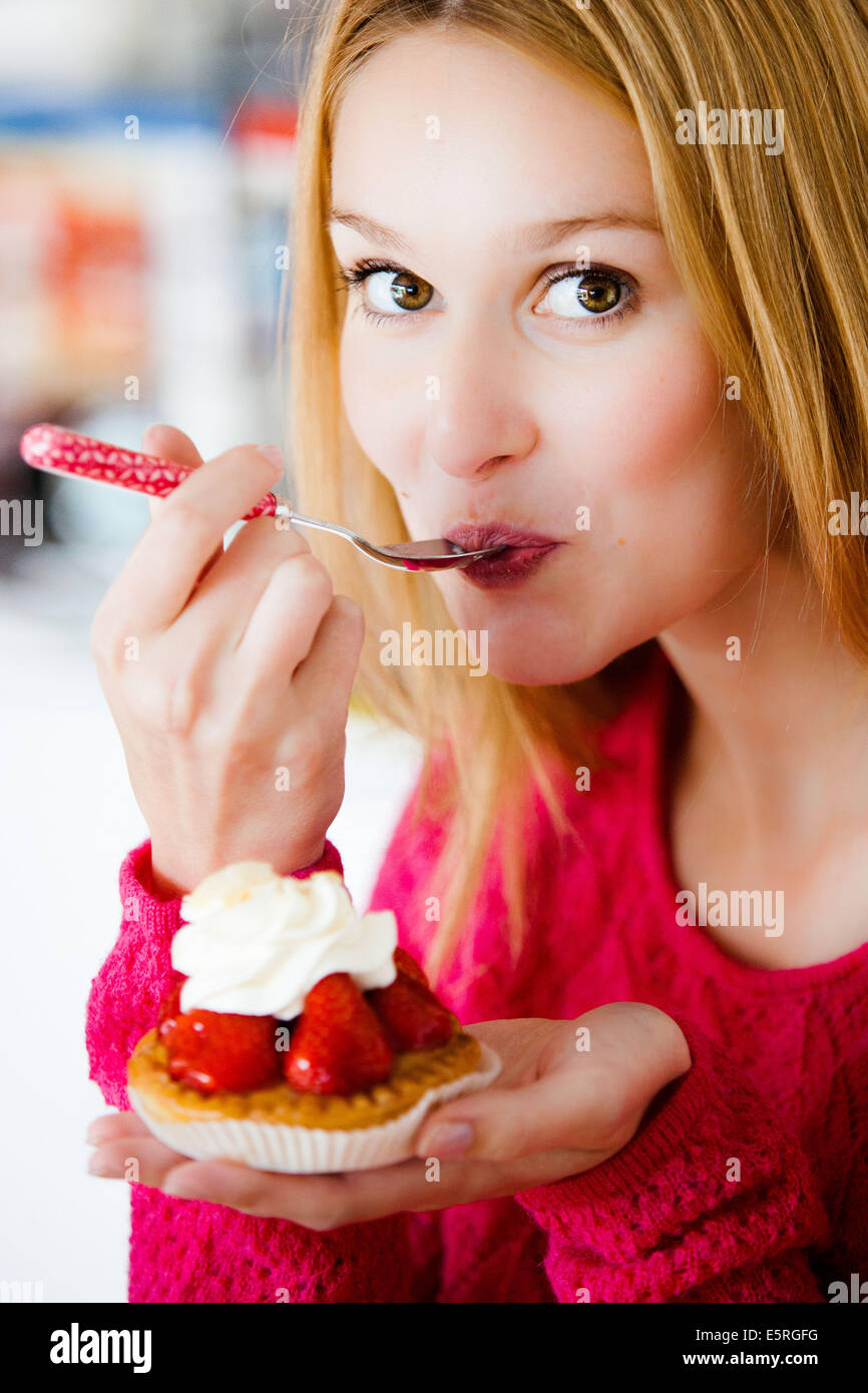 Woman eating pastry Stock Photo - Alamy