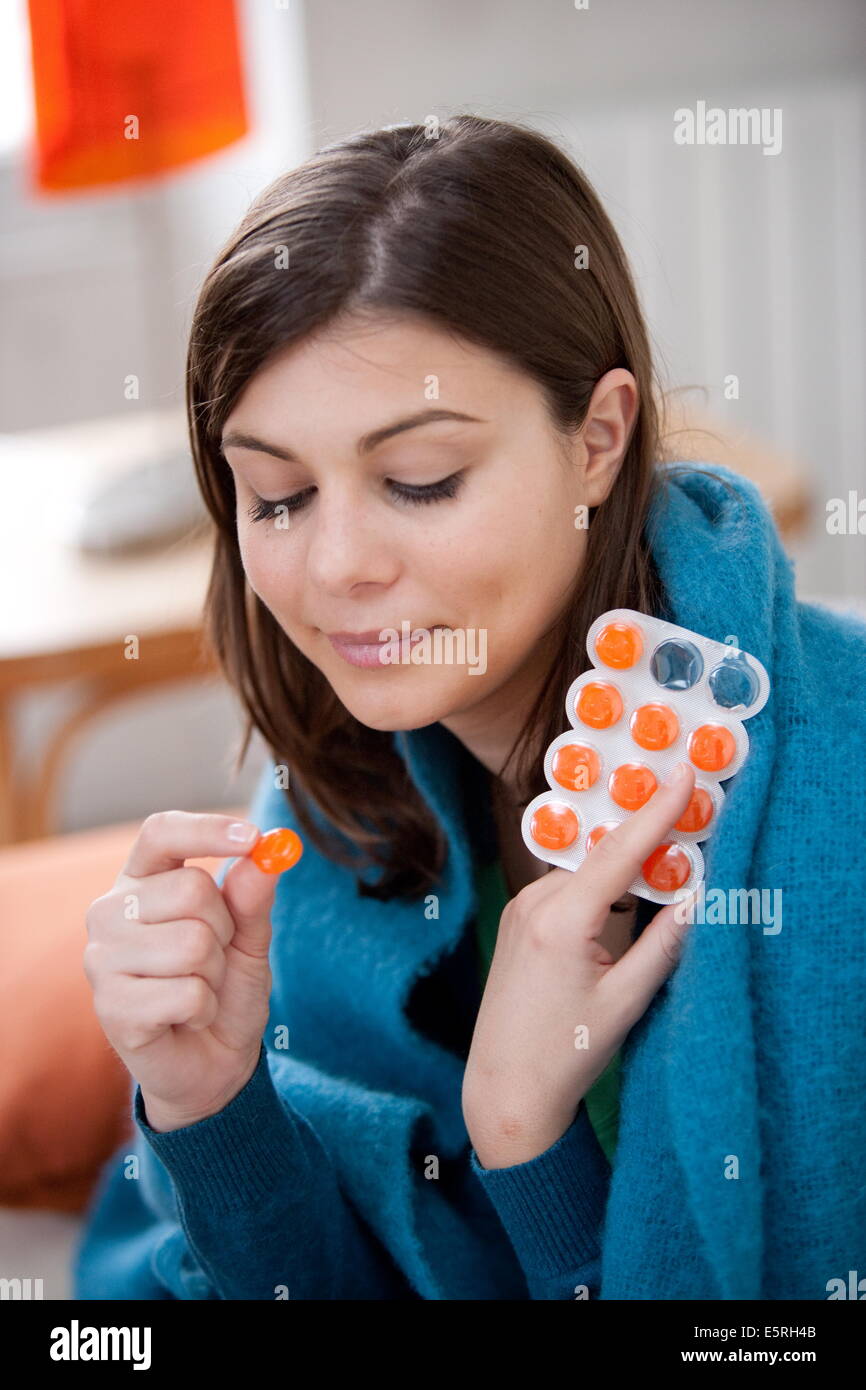 Woman taking lozenge for sorethroat Stock Photo - Alamy