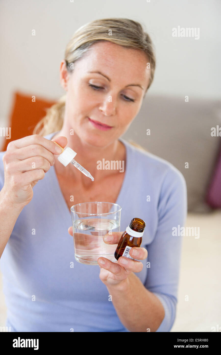 Woman taking drops of medicine Stock Photo - Alamy