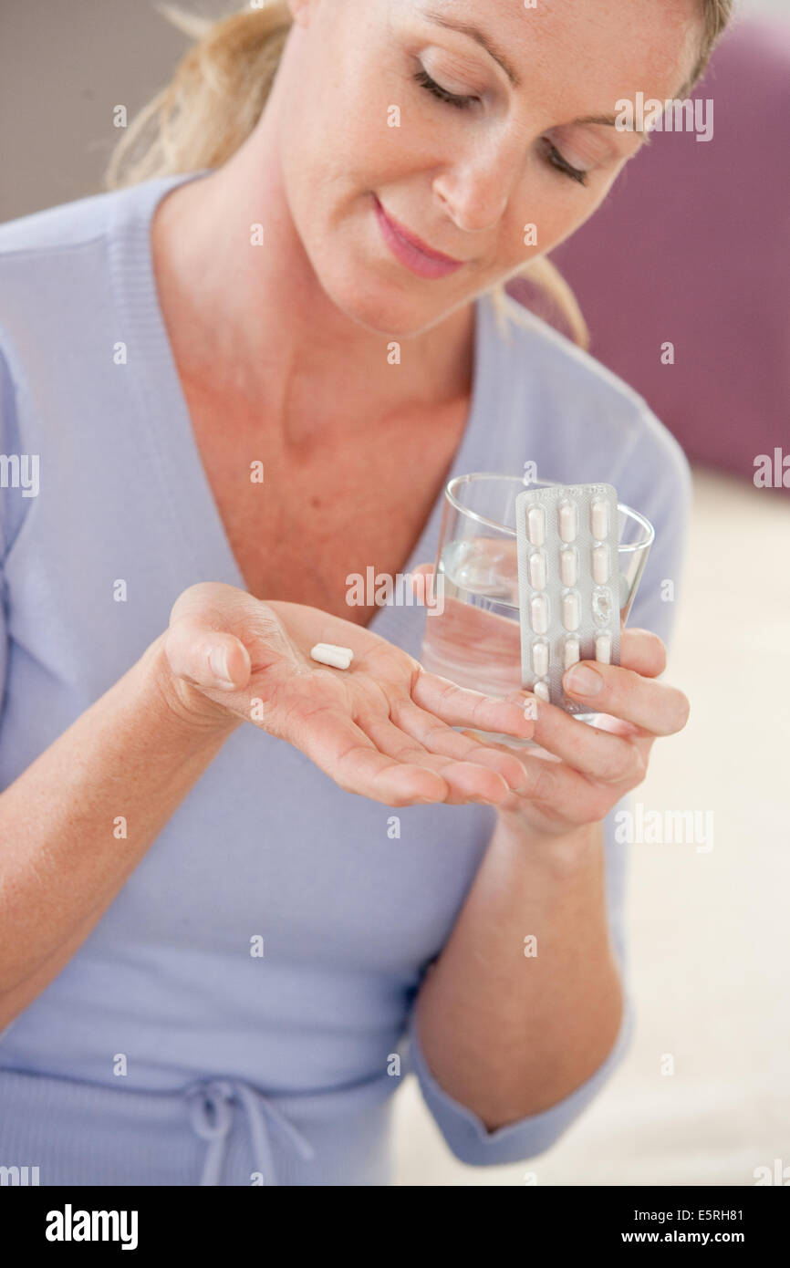 Woman taking medicine Stock Photo - Alamy