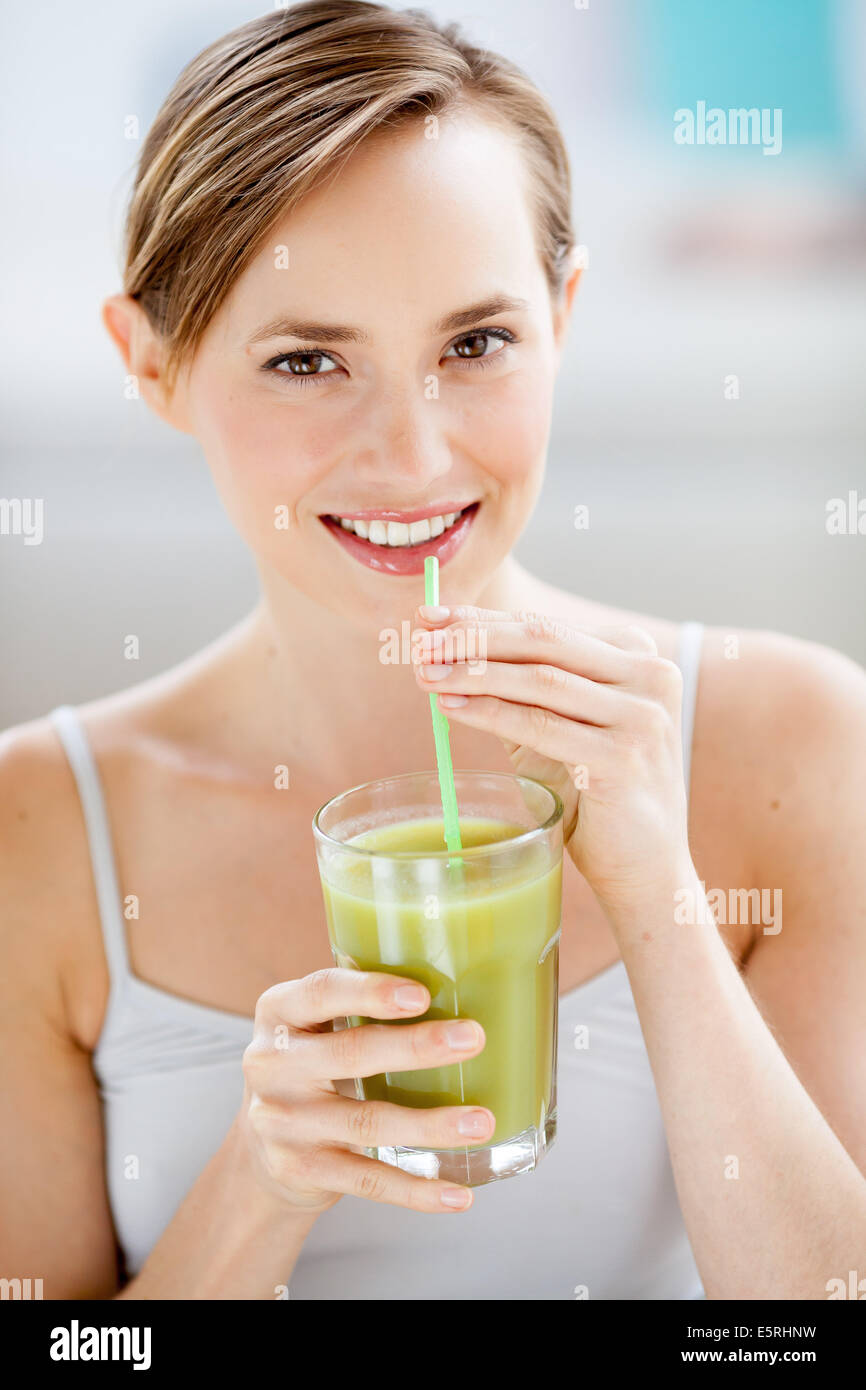 Woman drinking a smoothie (blended drink made from fruits Stock Photo ...