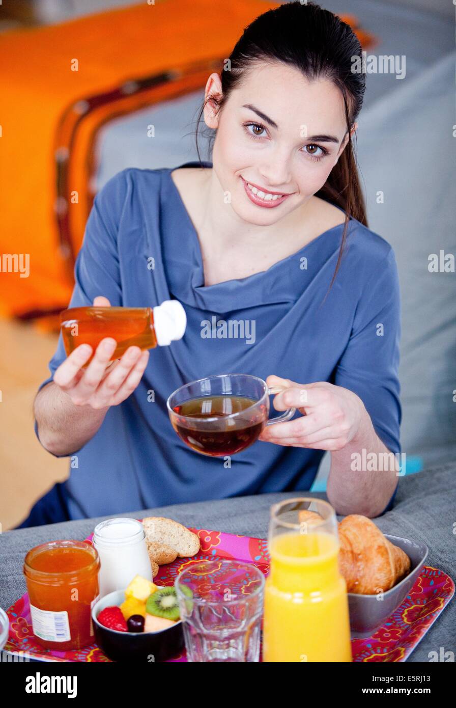 Woman adding of honey in an infusion Stock Photo - Alamy