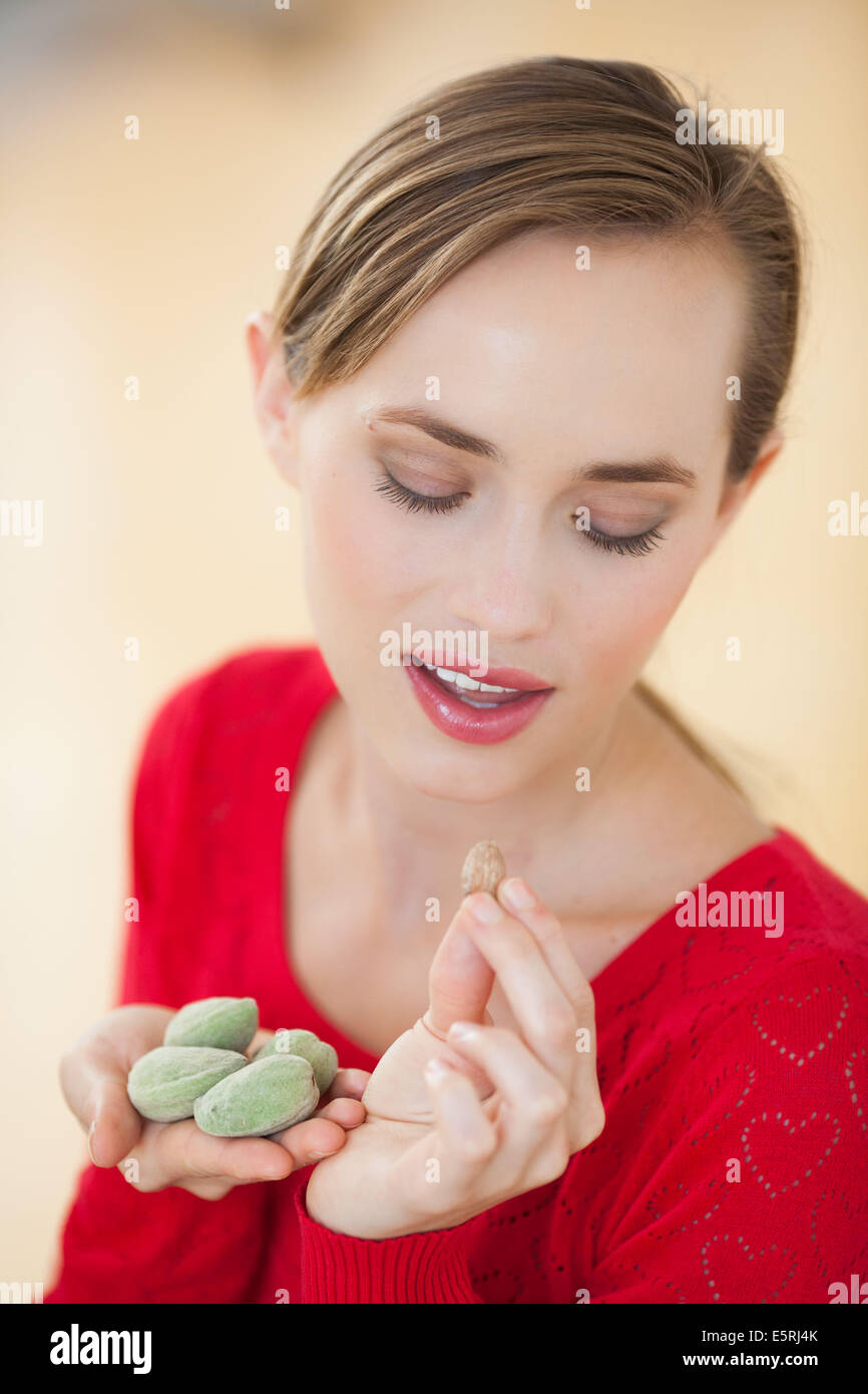 Woman eating almonds Stock Photo - Alamy