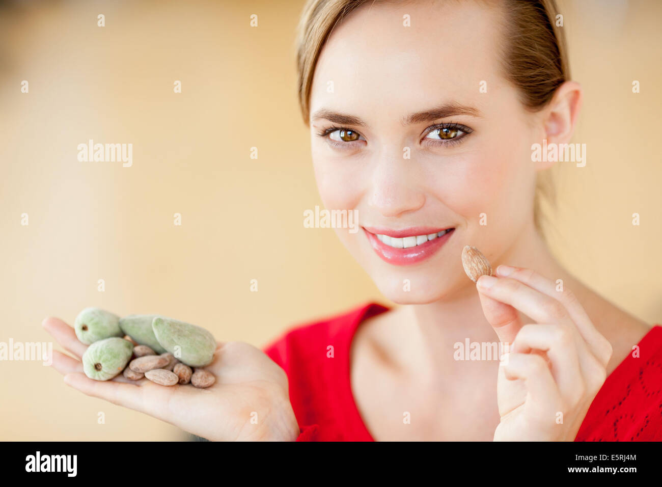Woman eating almonds Stock Photo - Alamy