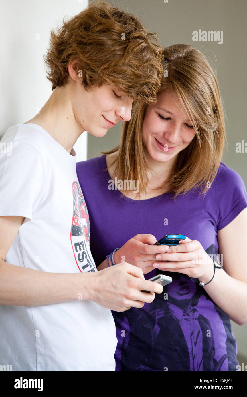 Teenagers sending short text message (sms) on cell phone Stock Photo ...