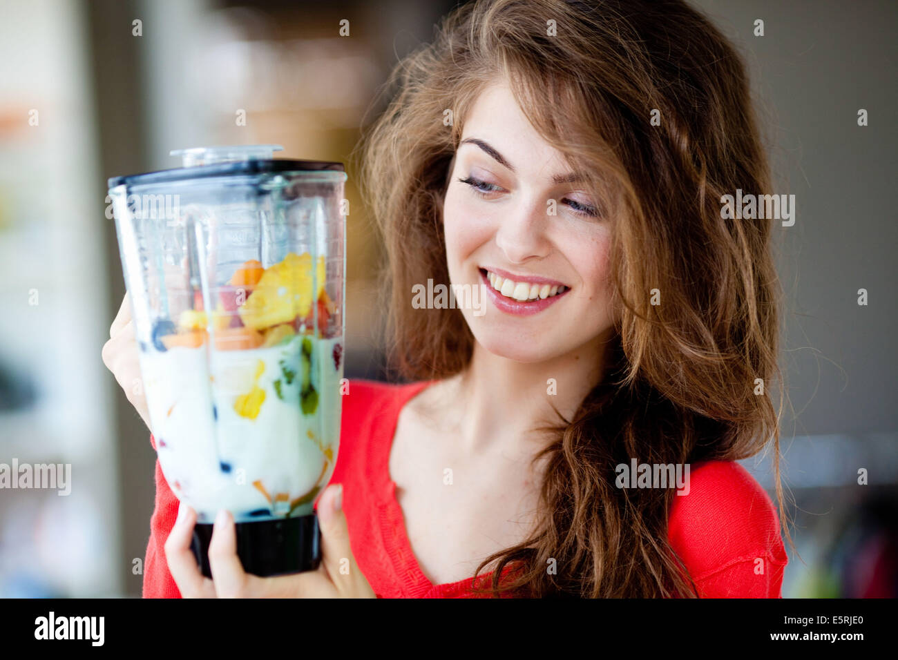 Woman making fruit smoothie in blender Stock Photo - Alamy