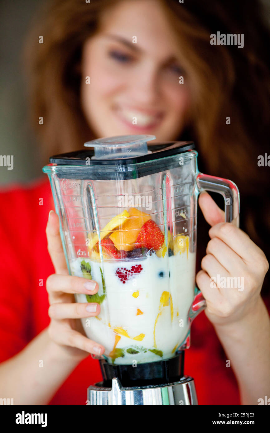 Woman making fruit smoothie in blender Stock Photo - Alamy