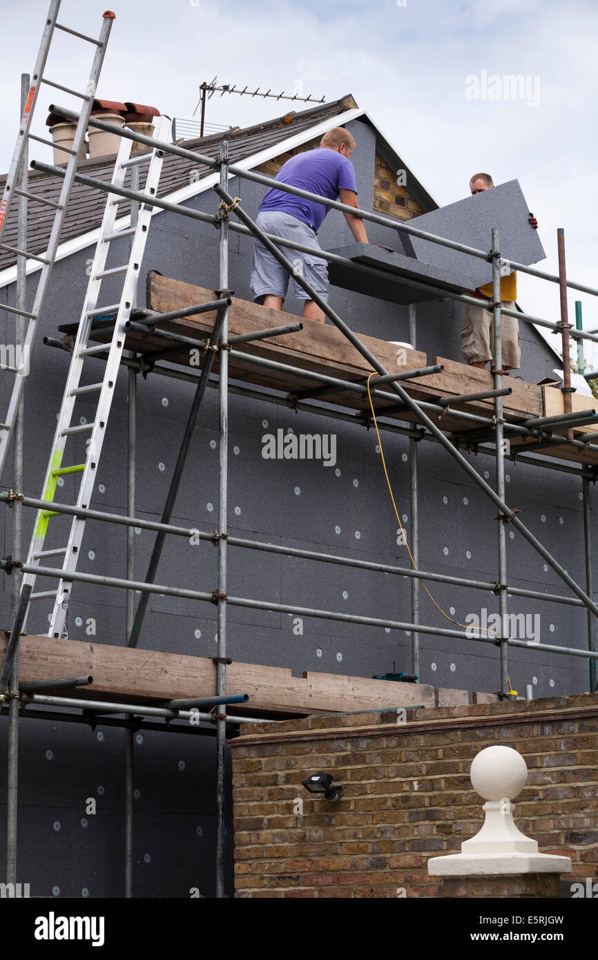 Builders attaching / fitting rigid foam solid wall insulation ( SWI ...