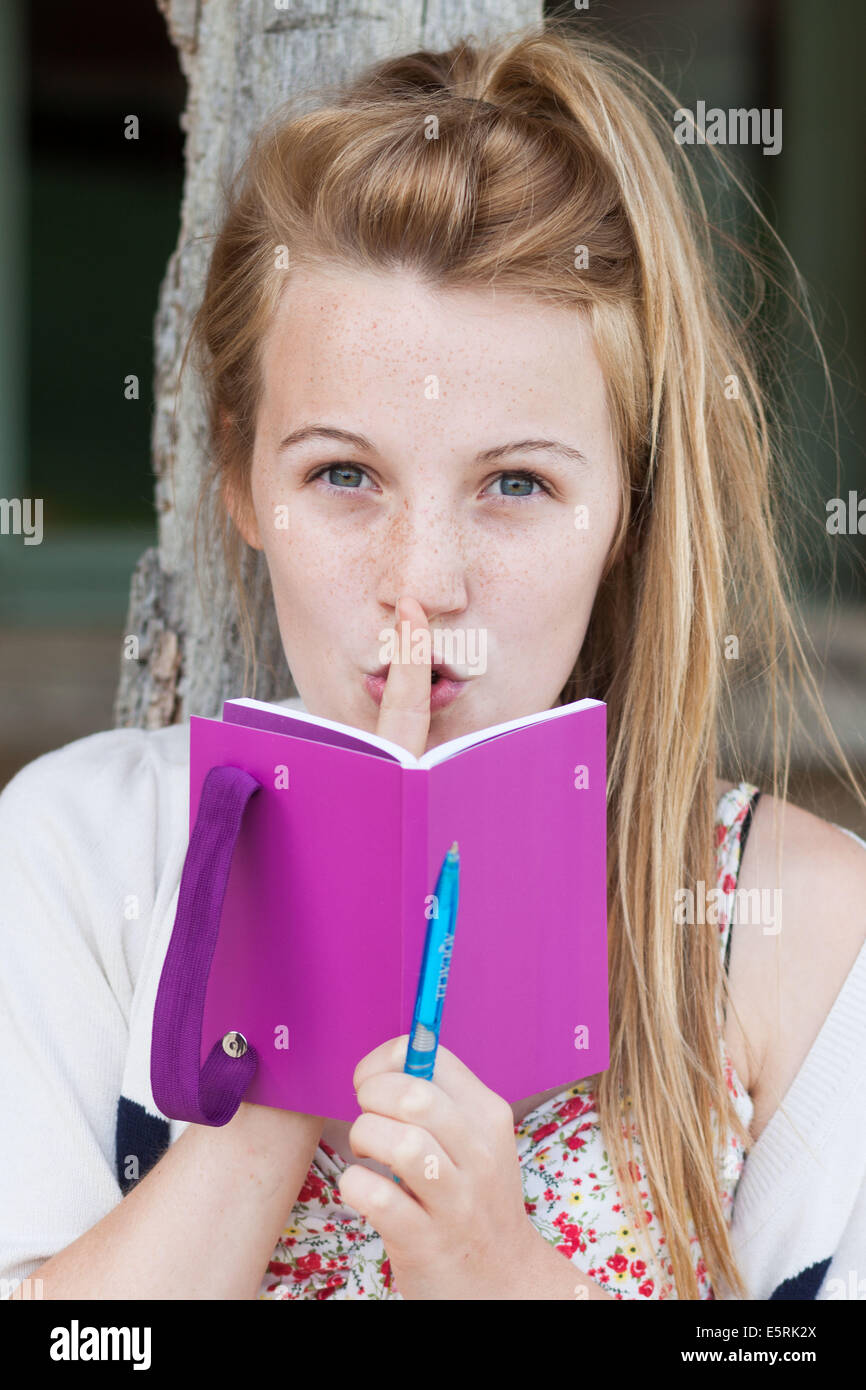 Teenage girl writing on her diary Stock Photo - Alamy