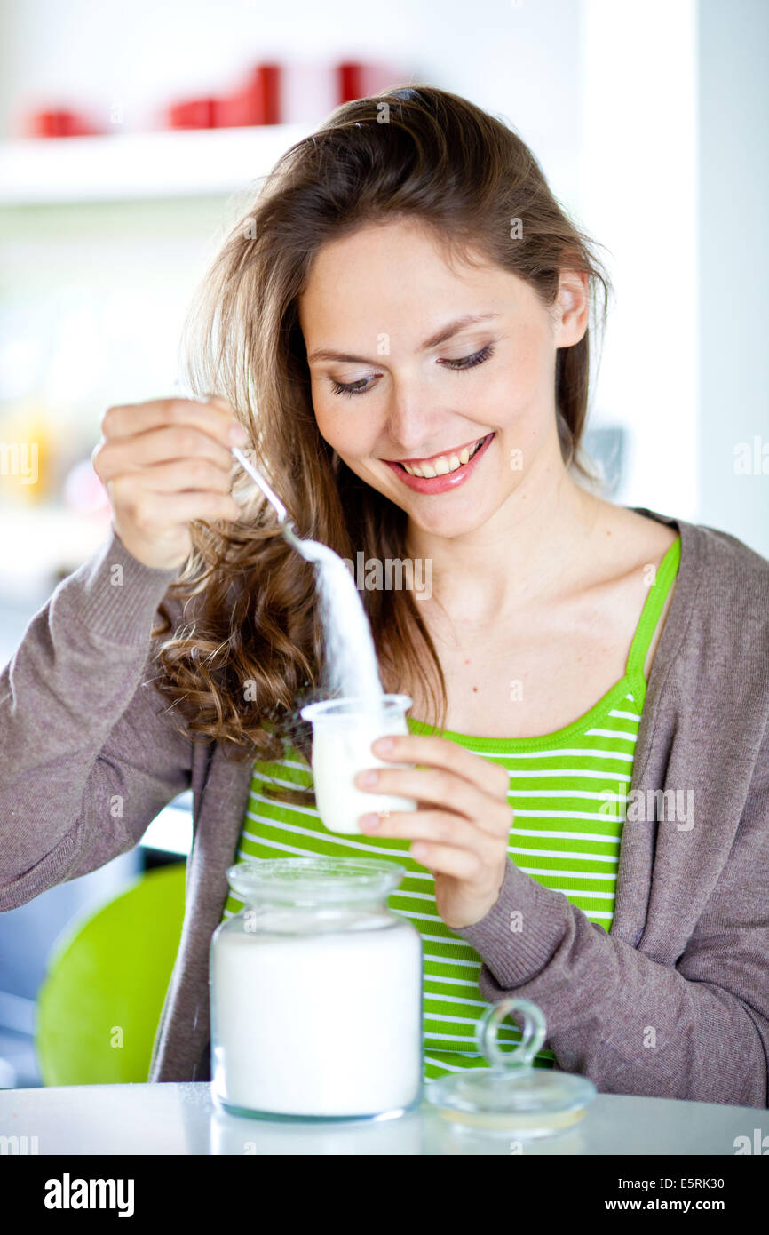 Woman adding sugar in yogurt Stock Photo - Alamy