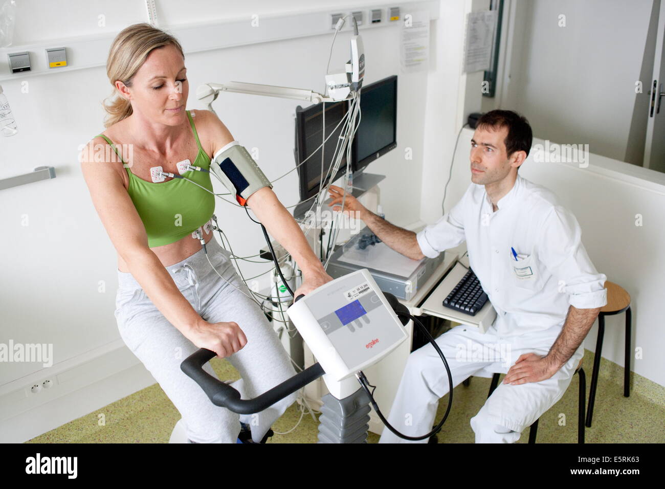 Female patient doing monitored heart rehabilitation training exercises ...