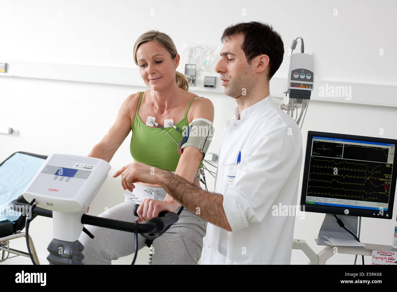 Female patient doing monitored heart rehabilitation training exercises ...
