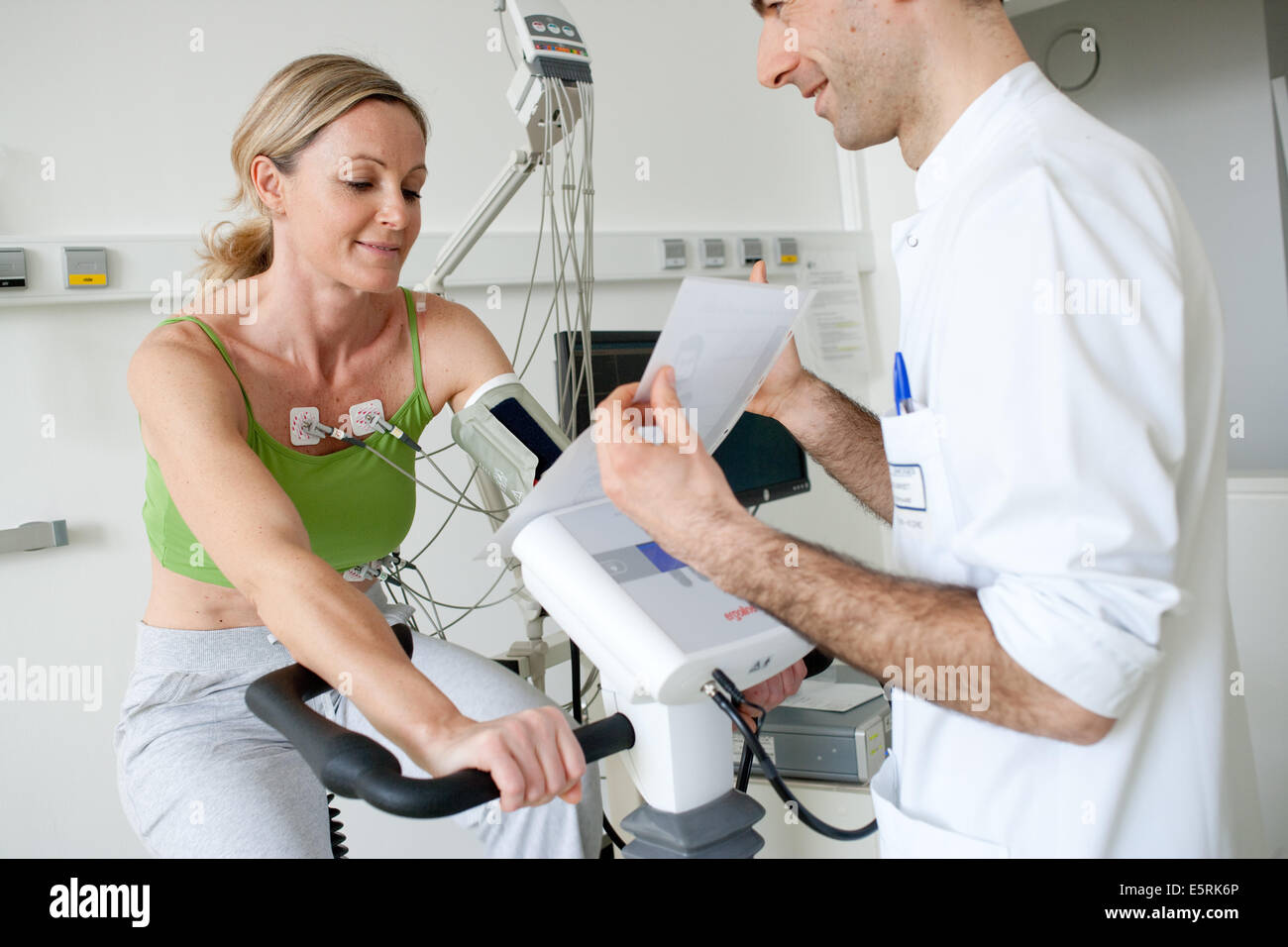 Female patient doing monitored heart rehabilitation training exercises ...