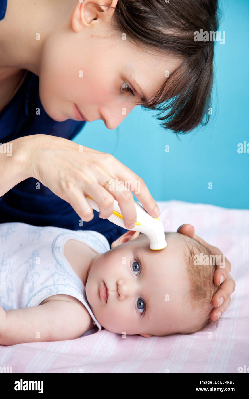 Checking the temperature of 5 month old baby with forehead thermometer ...
