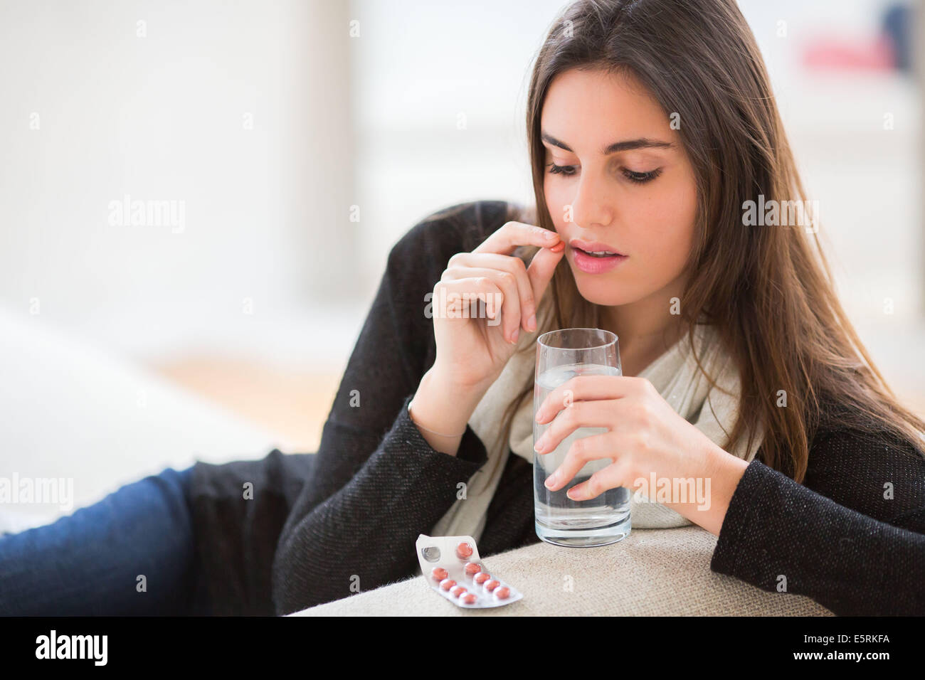 Woman taking tablets Stock Photo - Alamy
