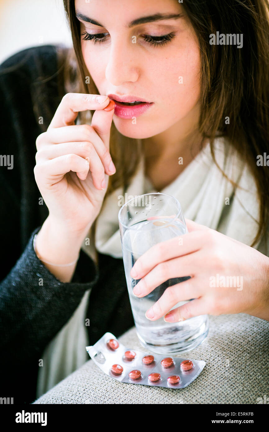 Woman taking tablets Stock Photo - Alamy