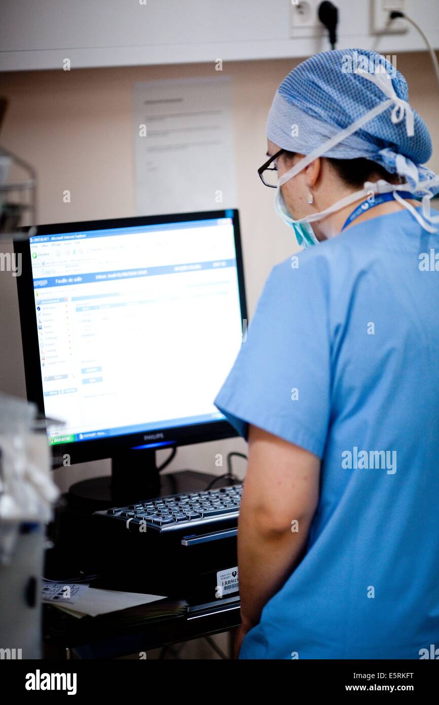 Nurse using computer in an operating theatre, Lariboisiere hospital ...