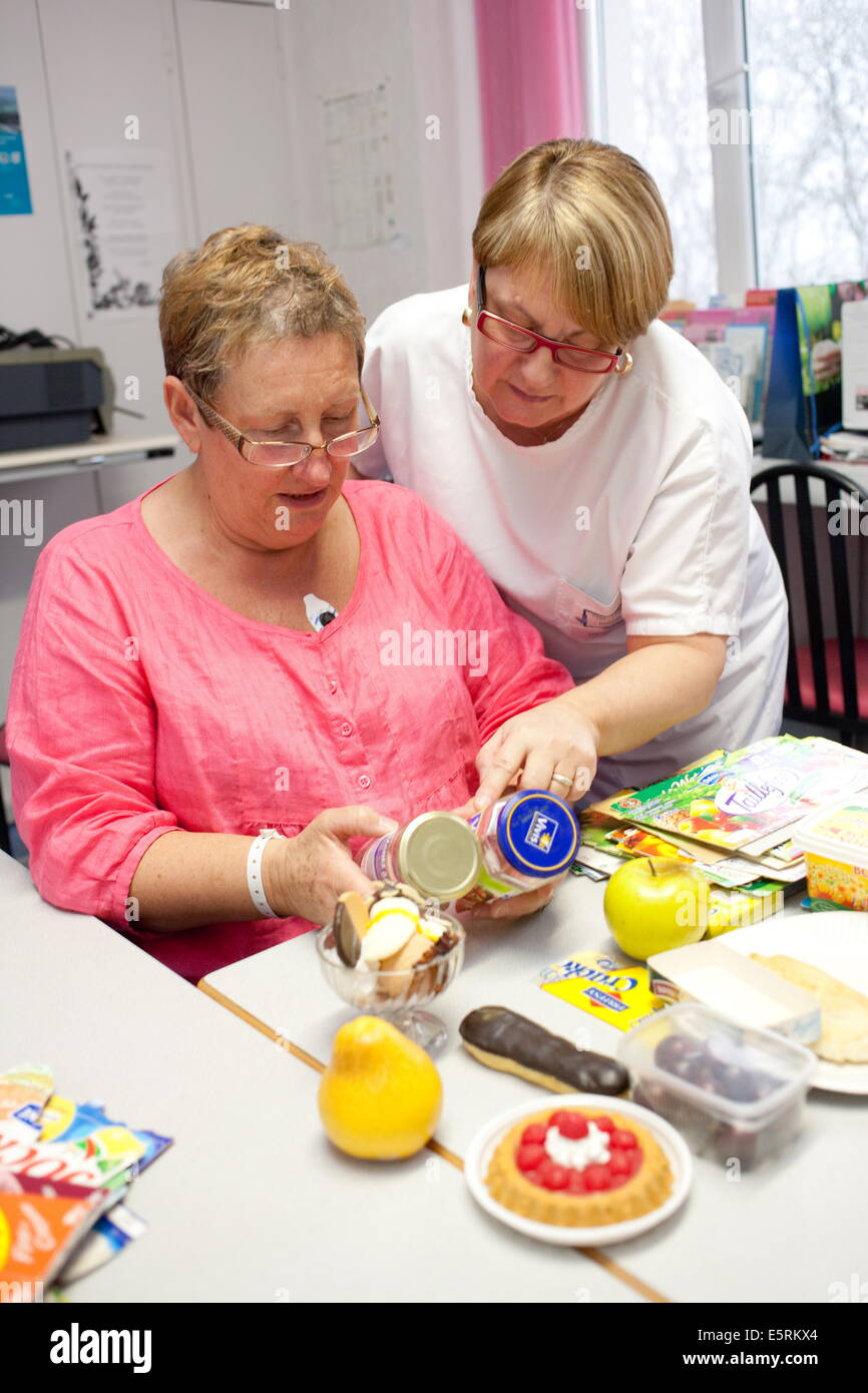 A nurse is holding a nutritional education workshop for obese patients ...