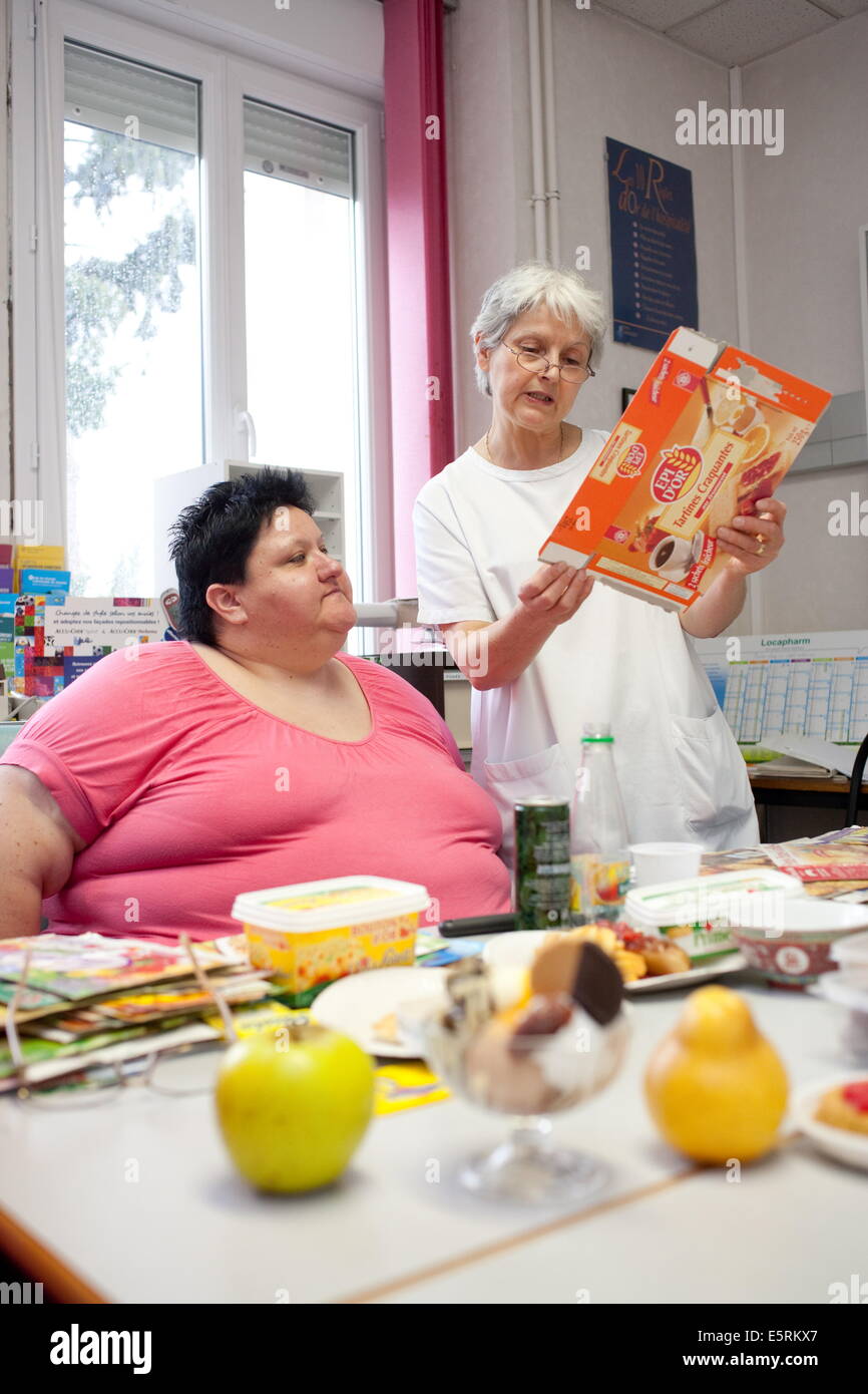 A nurse is holding a nutritional education workshop for obese patients ...