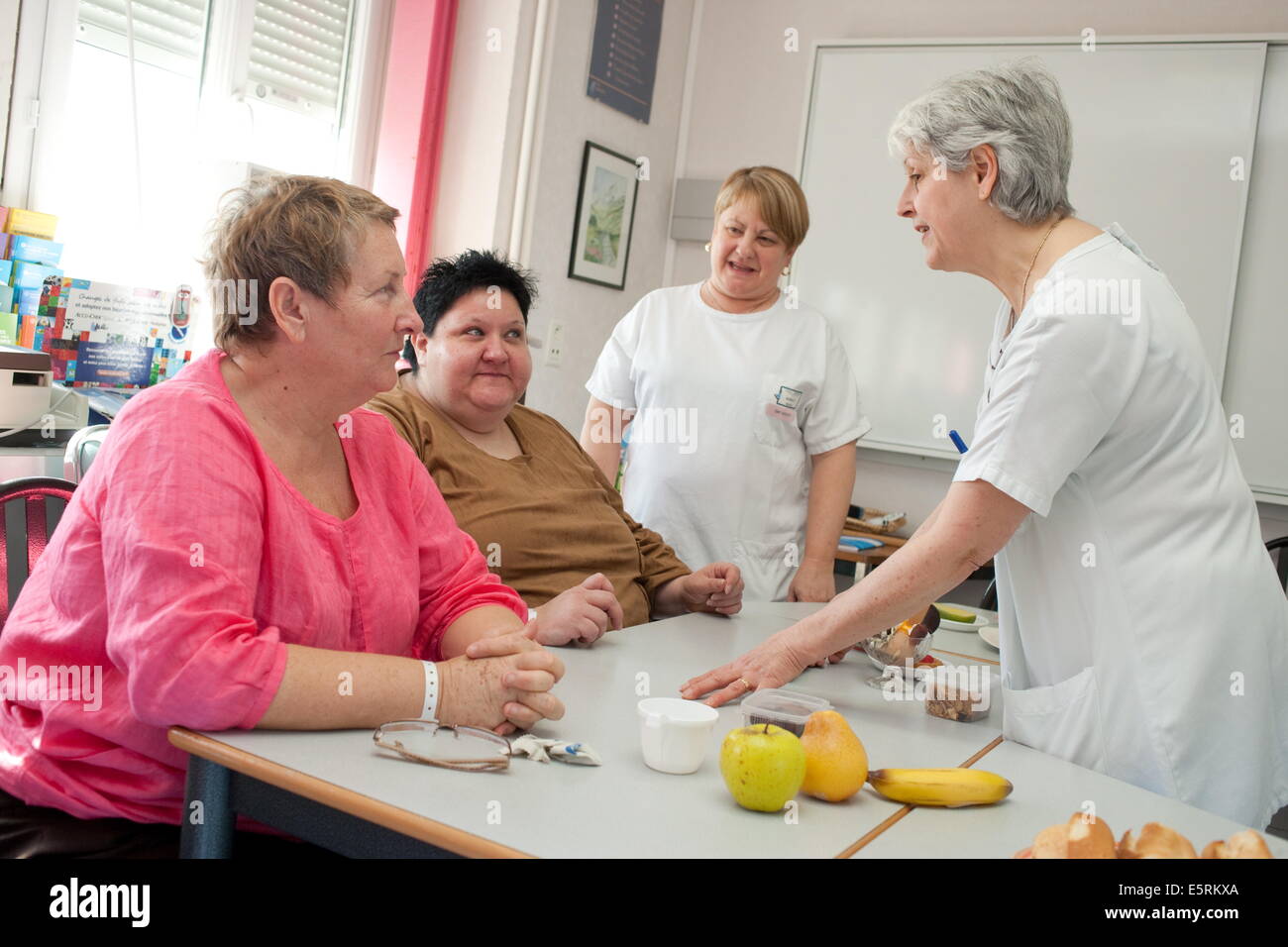 A nurse is holding a nutritional education workshop for obese patients ...
