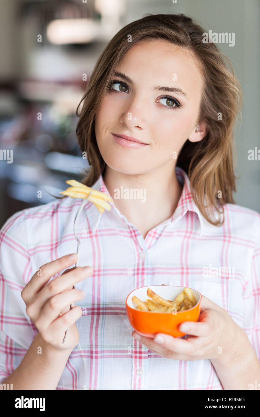 Woman eating french fries Stock Photo - Alamy