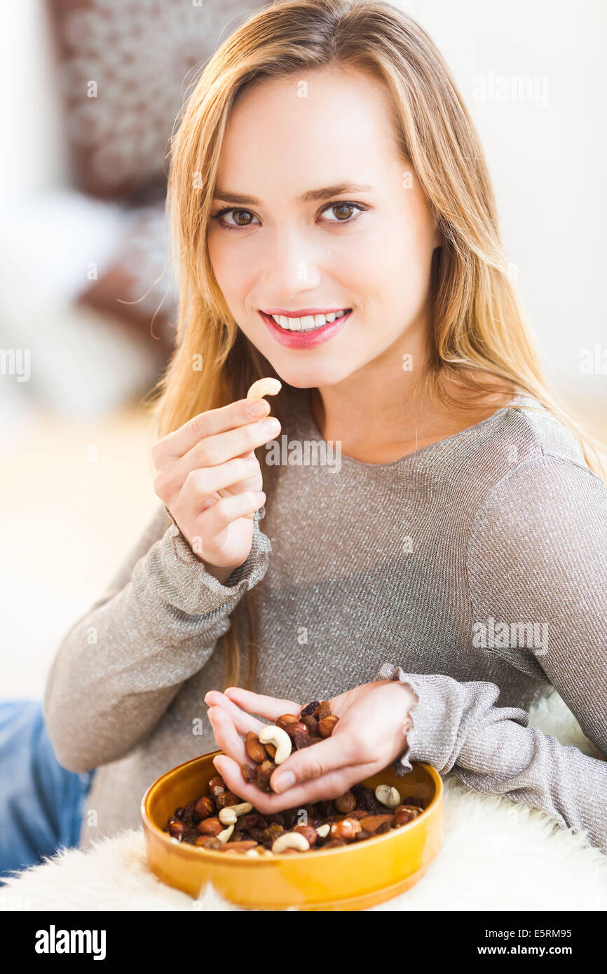 Woman eating several nuts Stock Photo - Alamy
