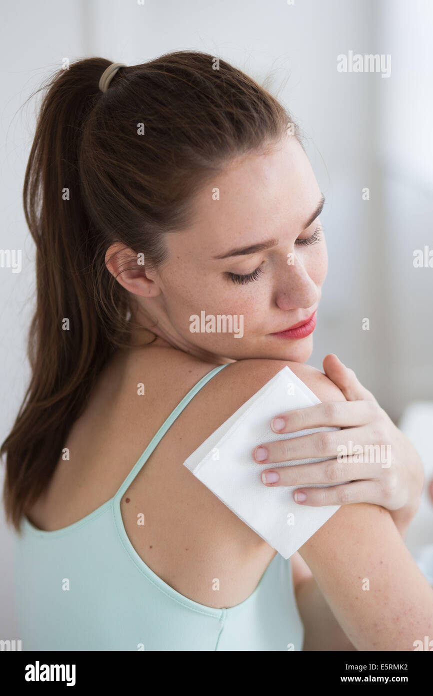 Woman applying a poultice on her shoulder Stock Photo - Alamy