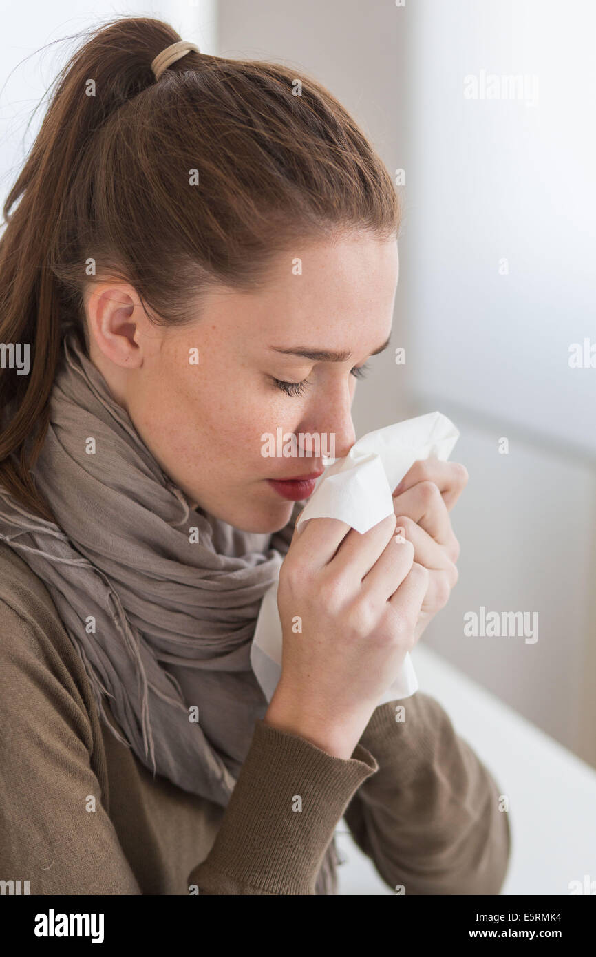 Woman with a cold using tissue Stock Photo - Alamy