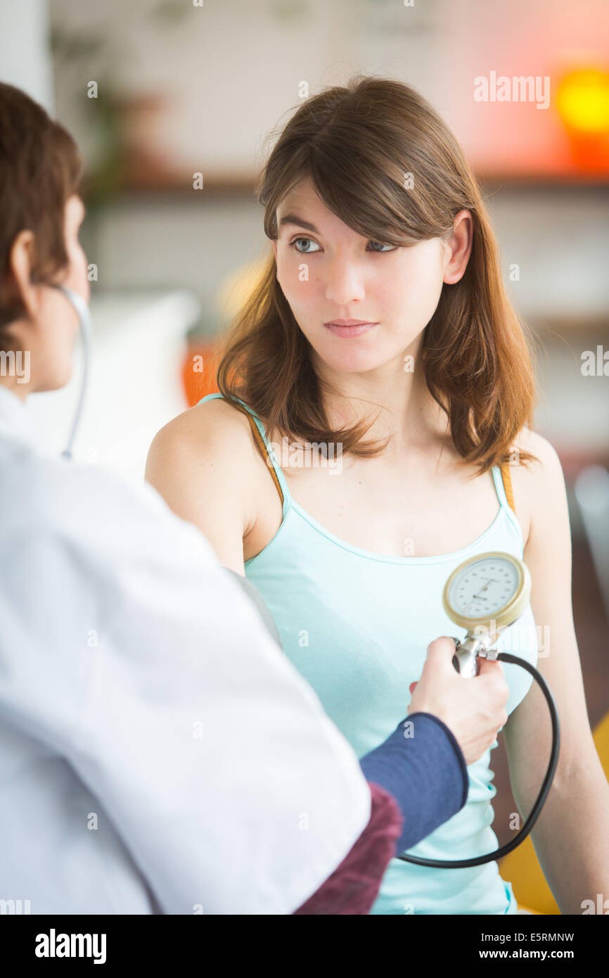 Doctor checking the blood pressure of a female patient Stock Photo - Alamy