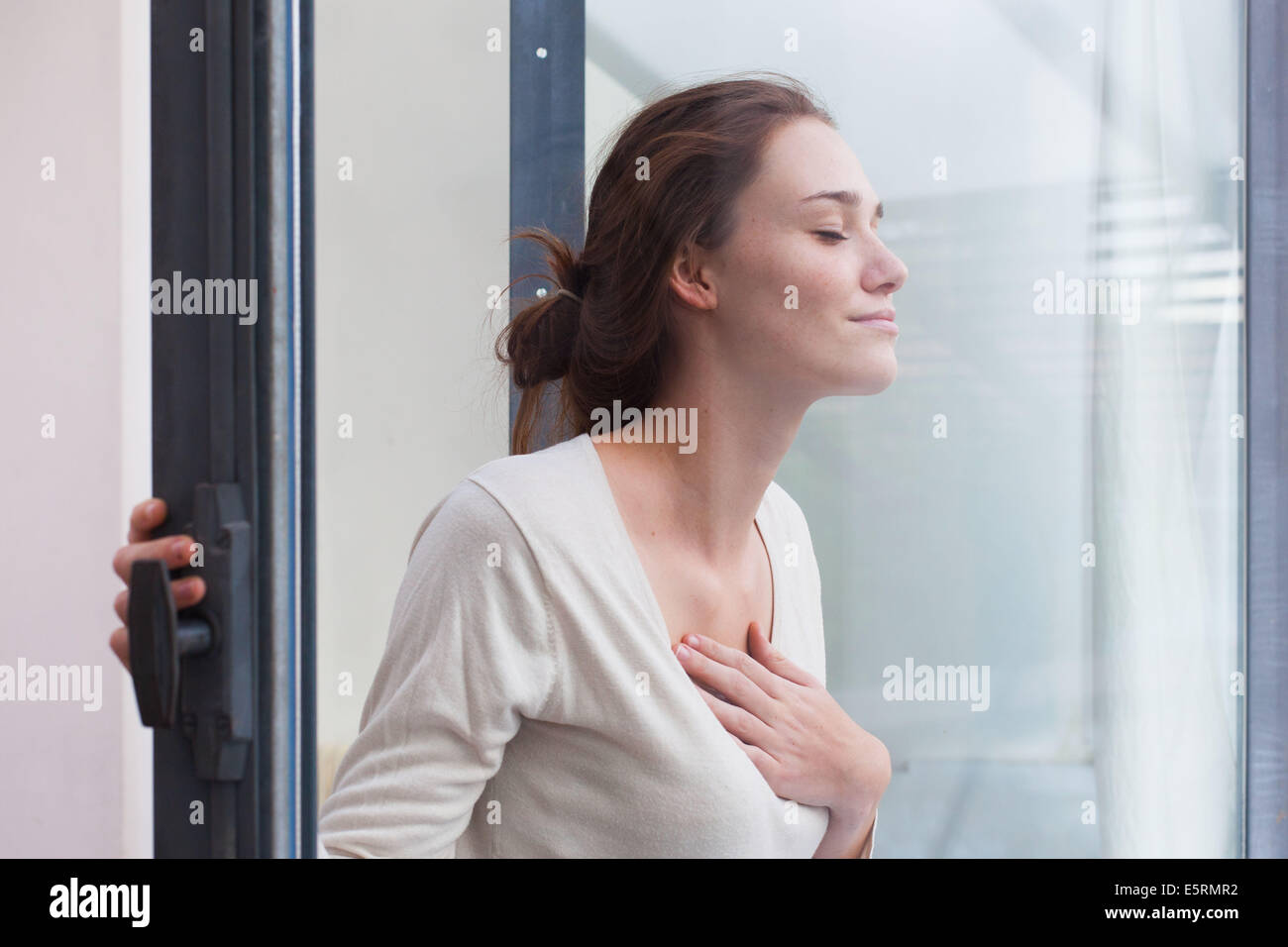 Woman opening window Stock Photo - Alamy