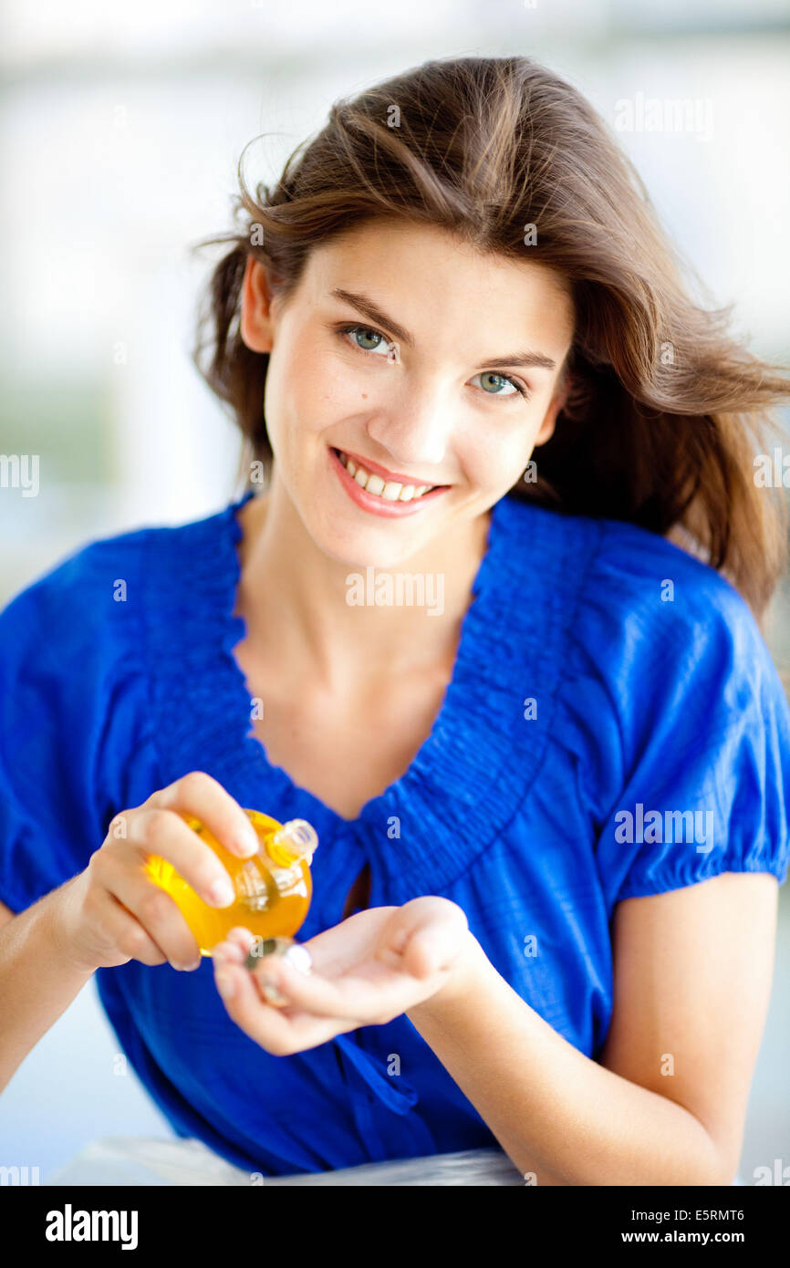 Woman using body oil Stock Photo - Alamy