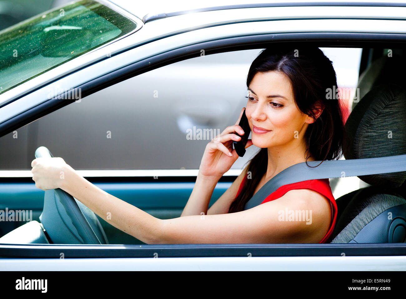 Woman using her cell phone when driving Stock Photo - Alamy