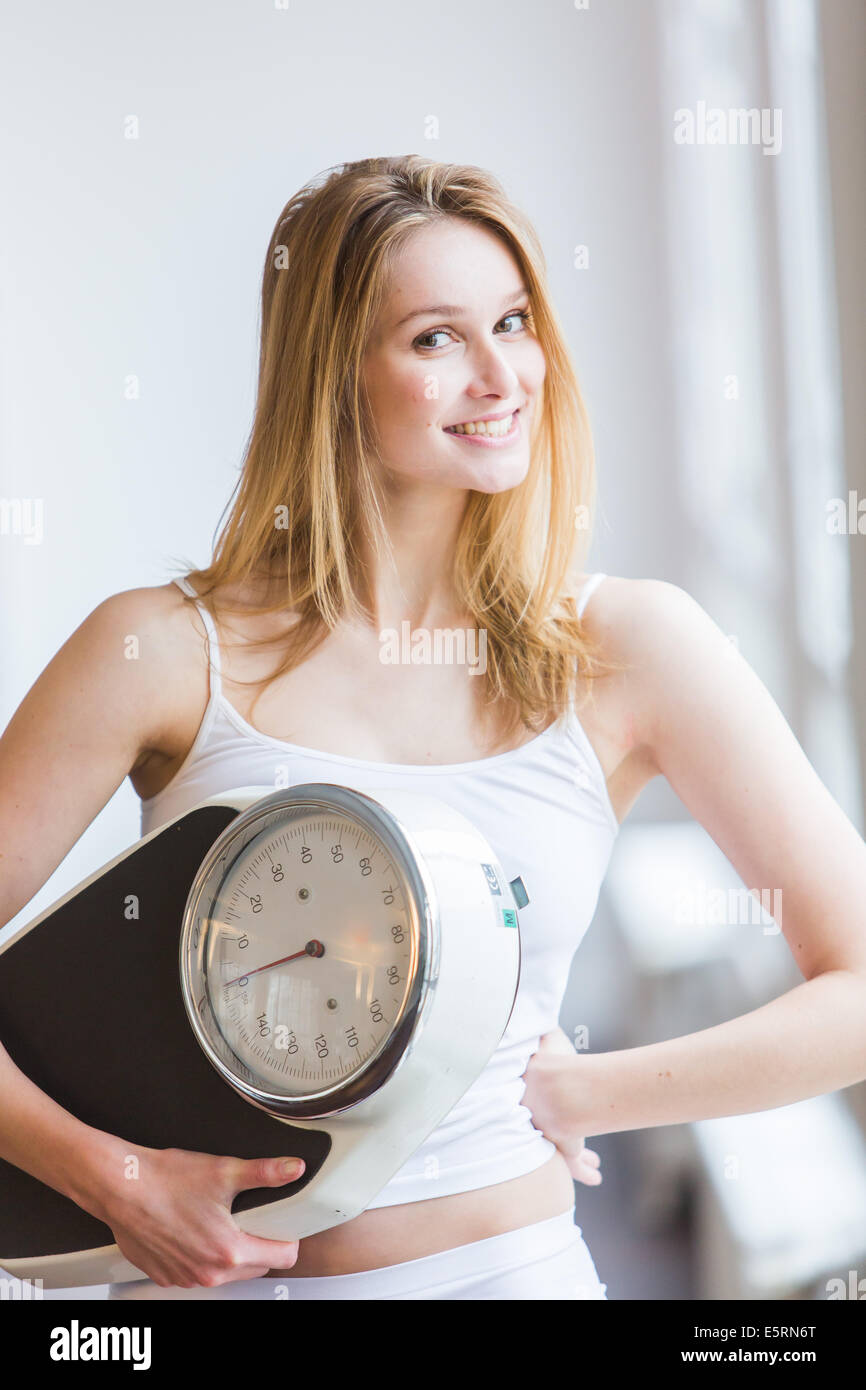 Woman holding on a scale Stock Photo - Alamy