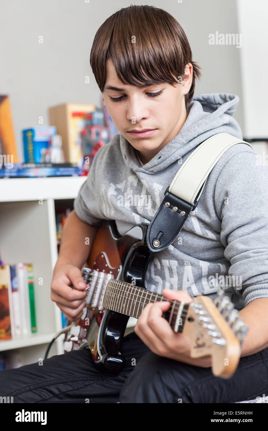 Teenage boy playing electric guitar Stock Photo - Alamy