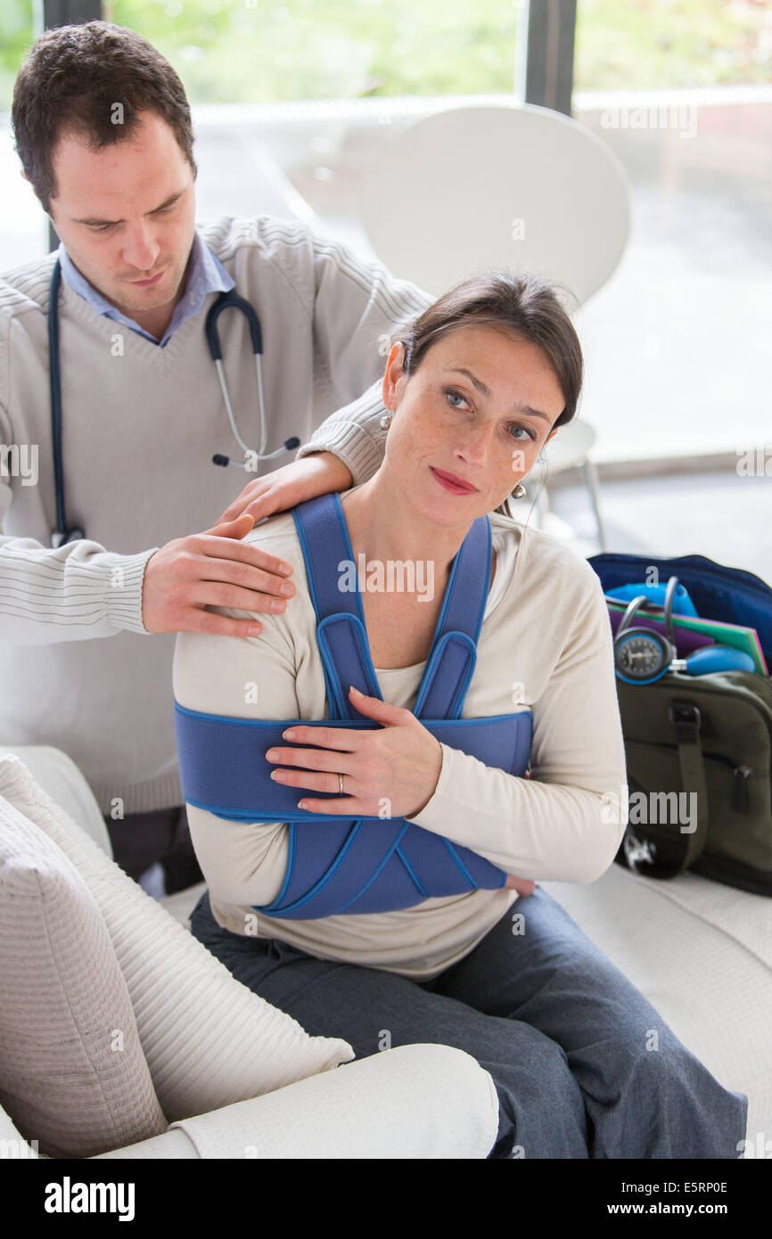 Doctor visiting female patient wearing a splint, at home Stock Photo ...