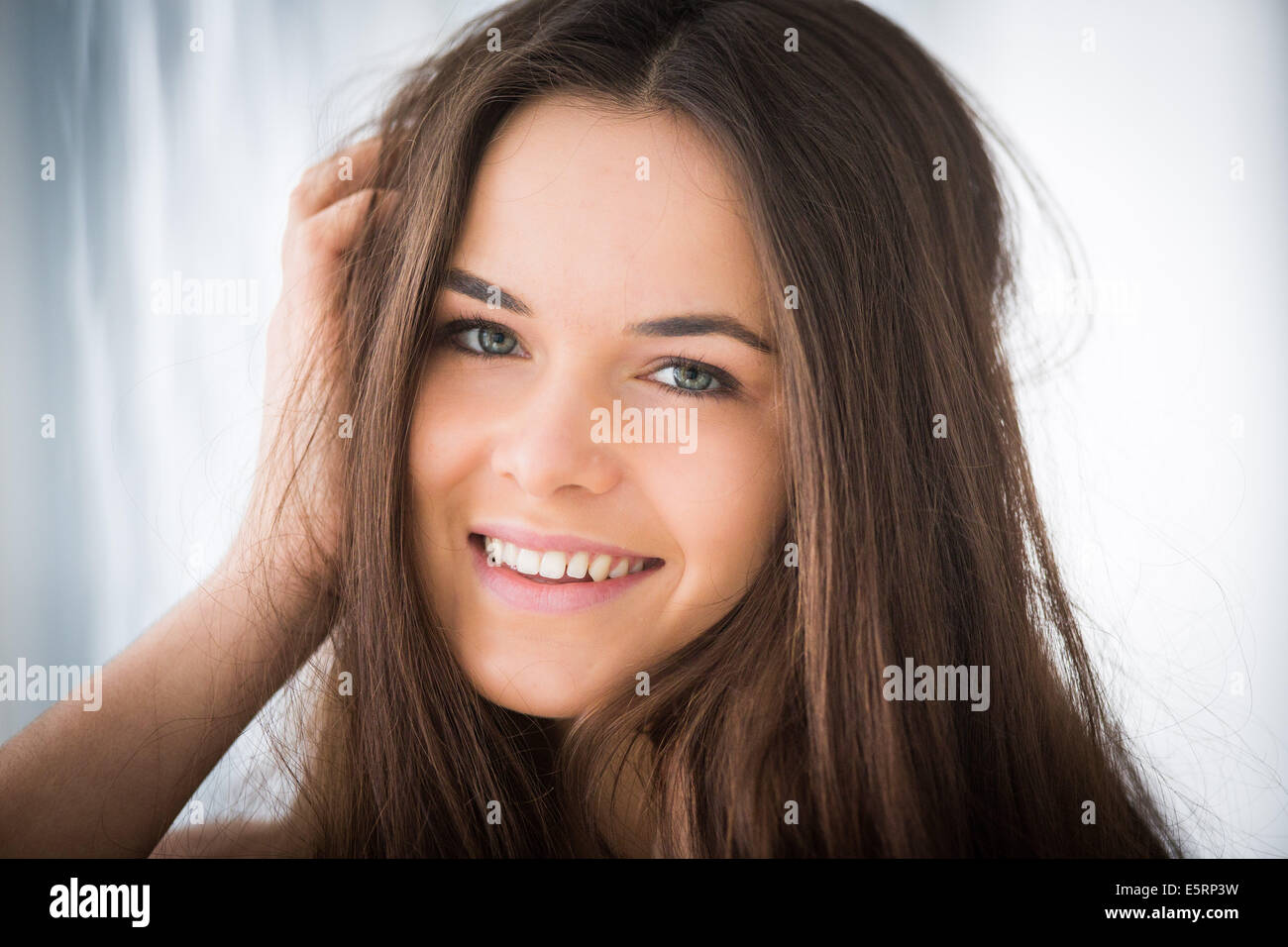Woman touching hair Stock Photo - Alamy
