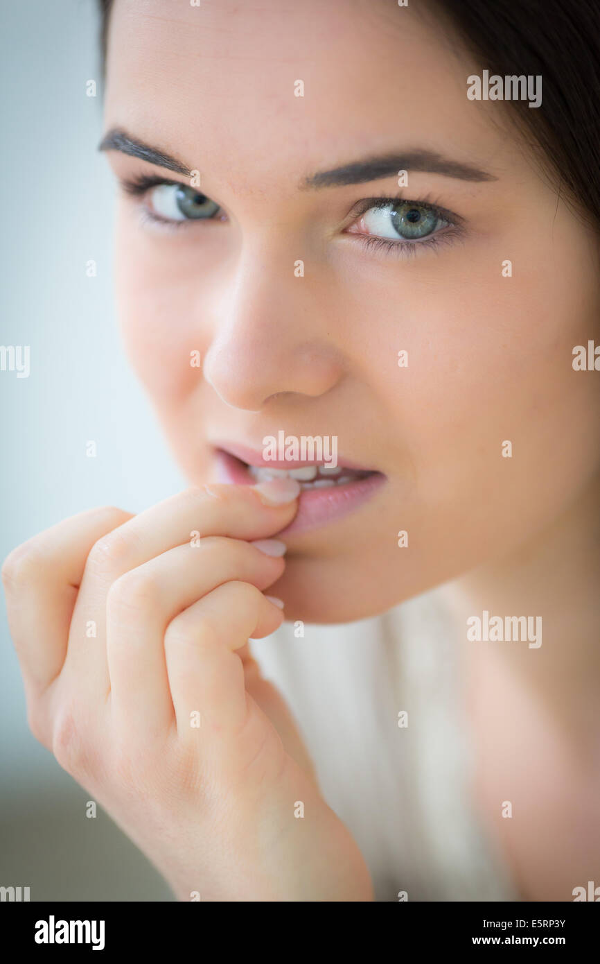 Woman chewing her thumbnail Stock Photo - Alamy