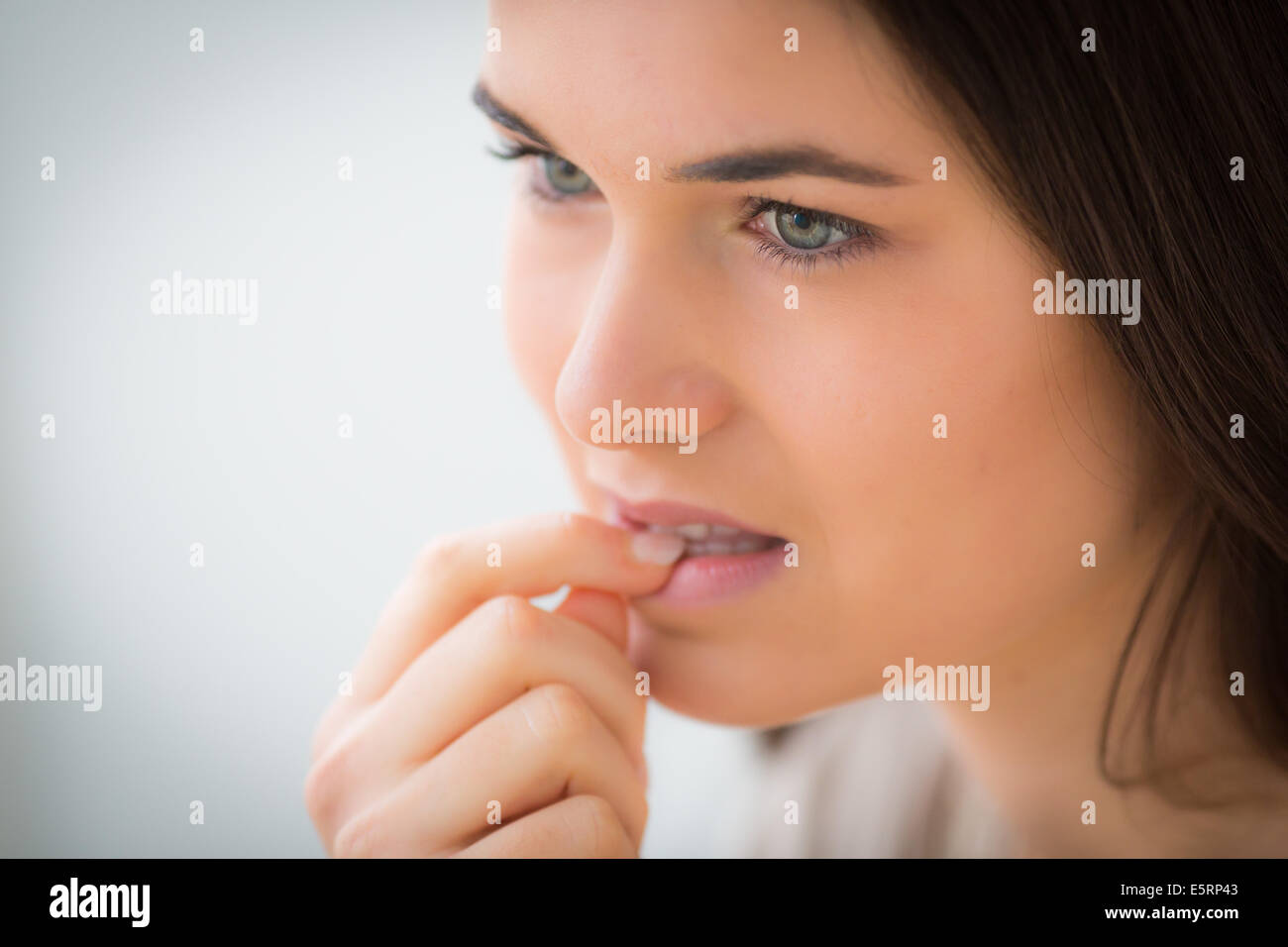 Woman chewing her thumbnail Stock Photo - Alamy