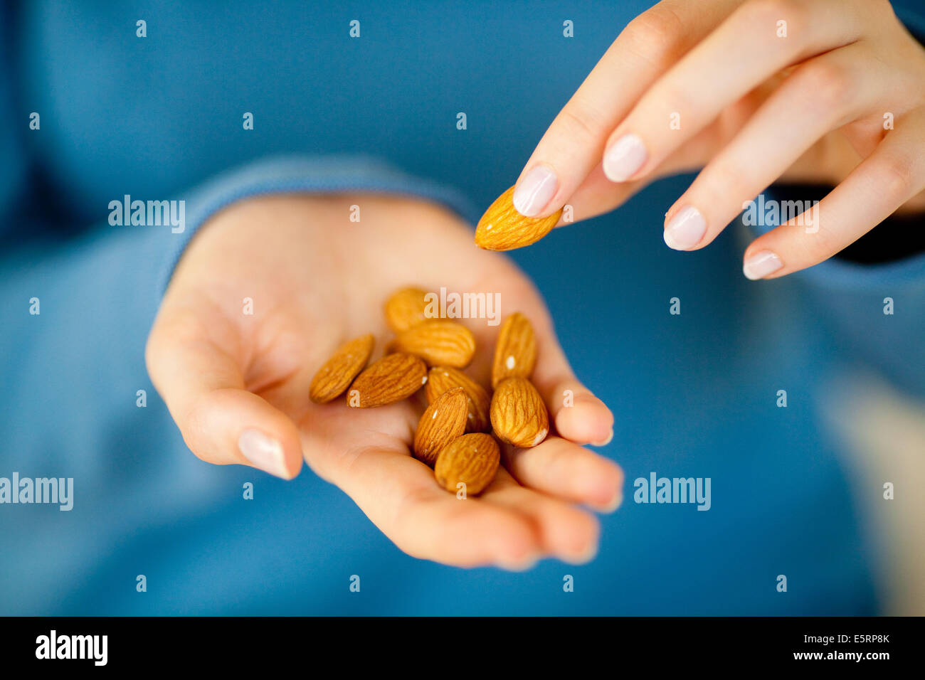 Woman eating almonds Stock Photo - Alamy